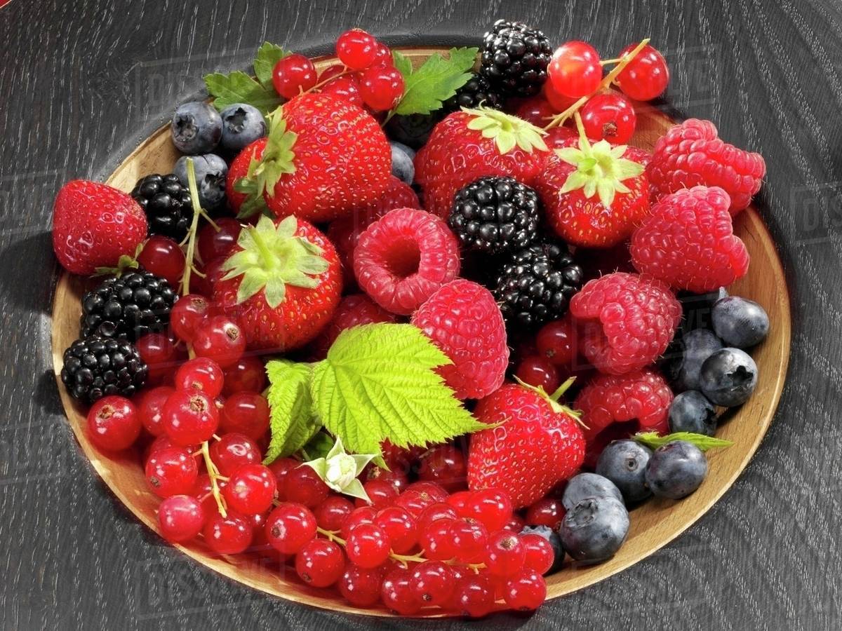 Assorted berries in wooden bowl - Stock Photo - Dissolve