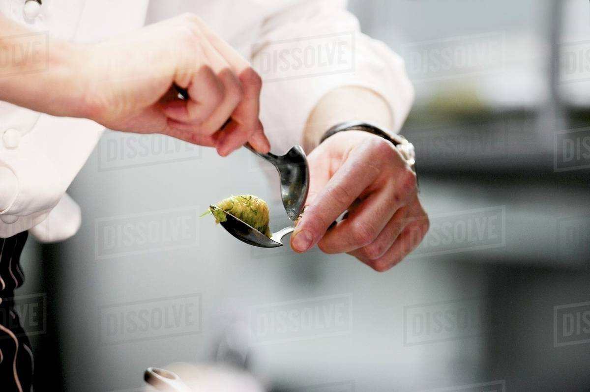 Chef shaping quenell during serice in working kitchen - Stock Photo ...