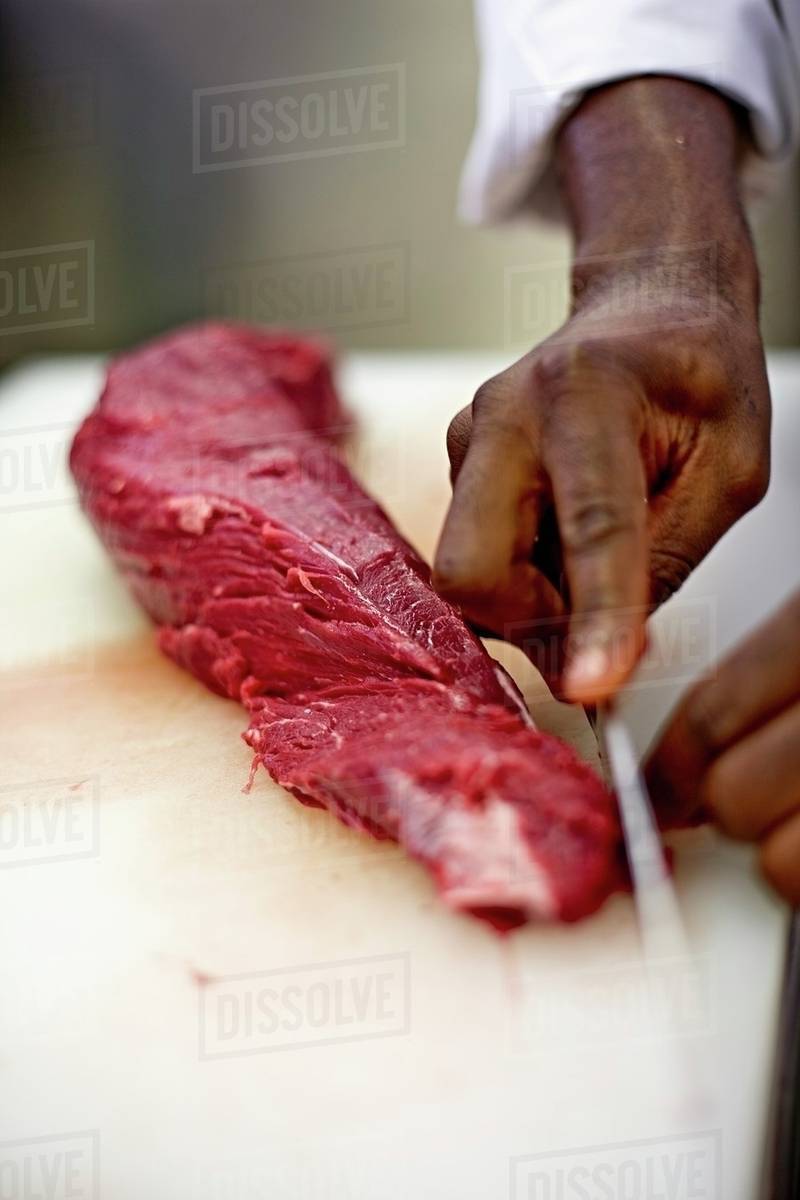 A cook removing the fat from a slice of beef - Royalty-free Stock Photo ...