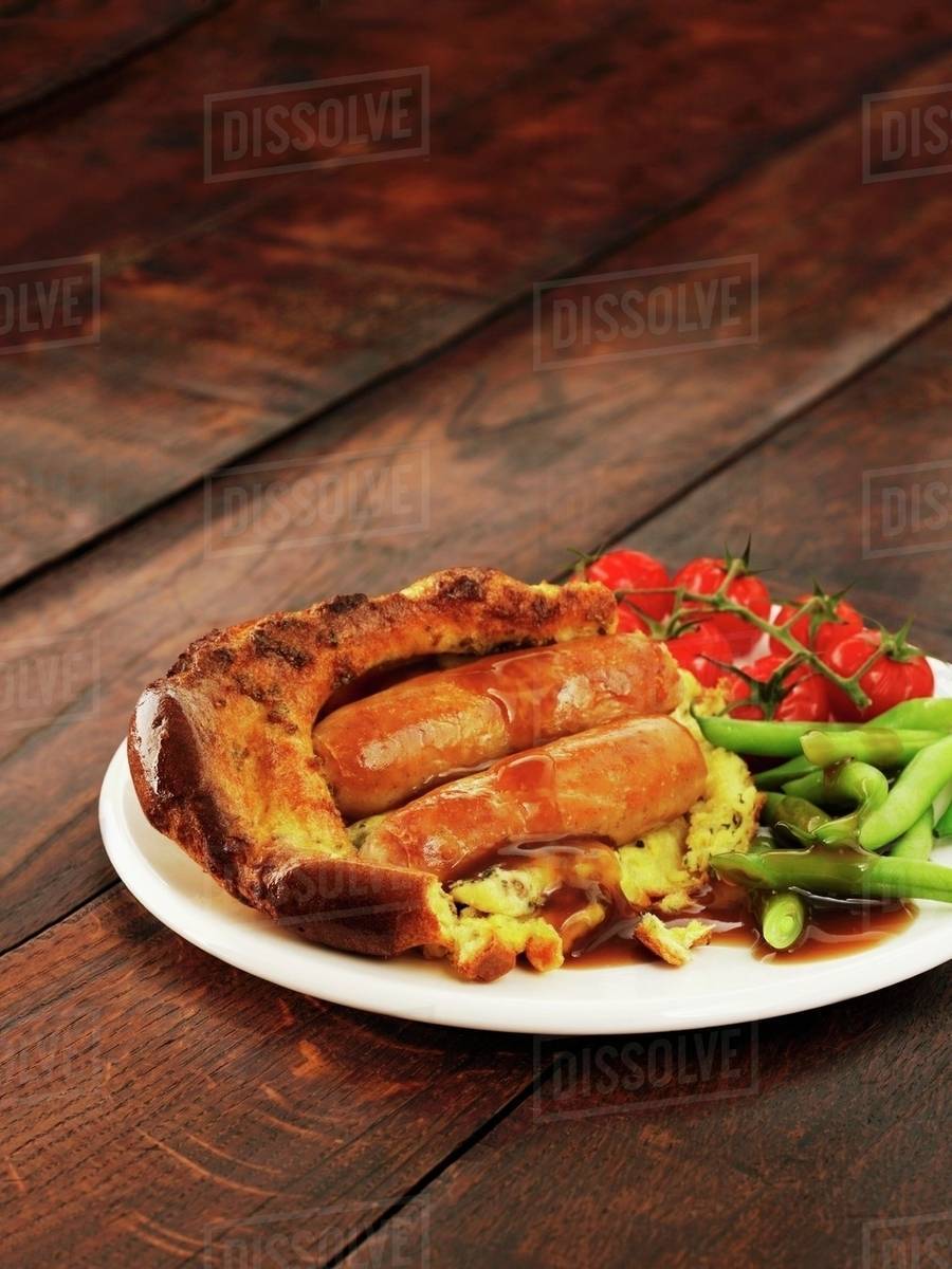 Toad in the hole with beans and tomatoes - Stock Photo - Dissolve