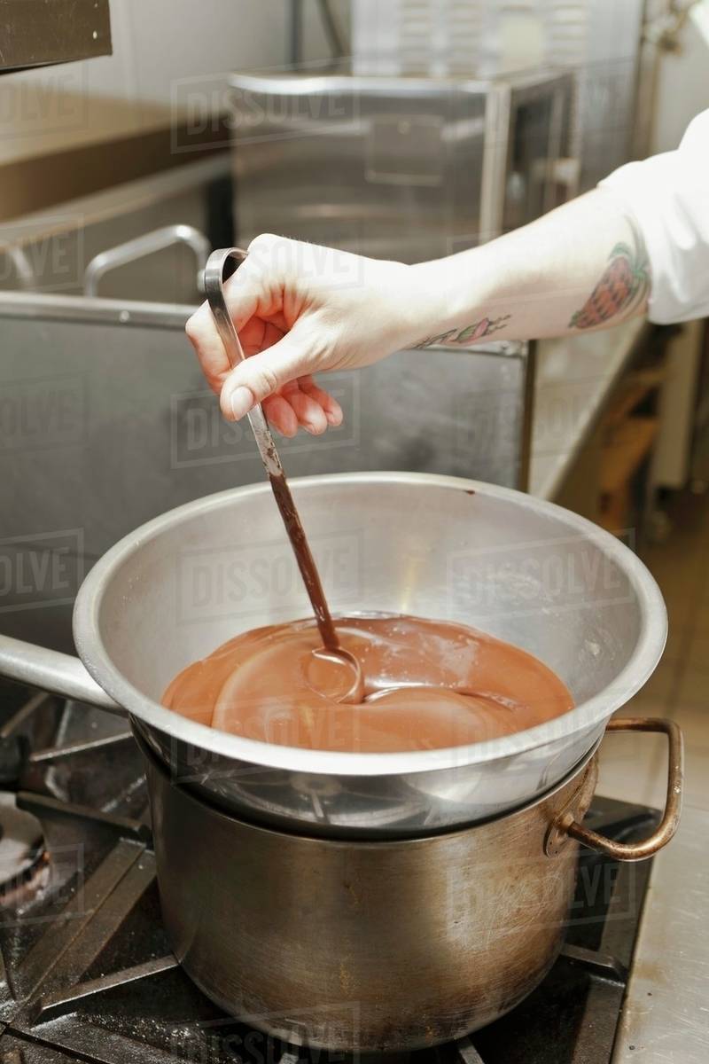 A chef stirring melted chocolate - Royalty-free Stock Photo | Dissolve