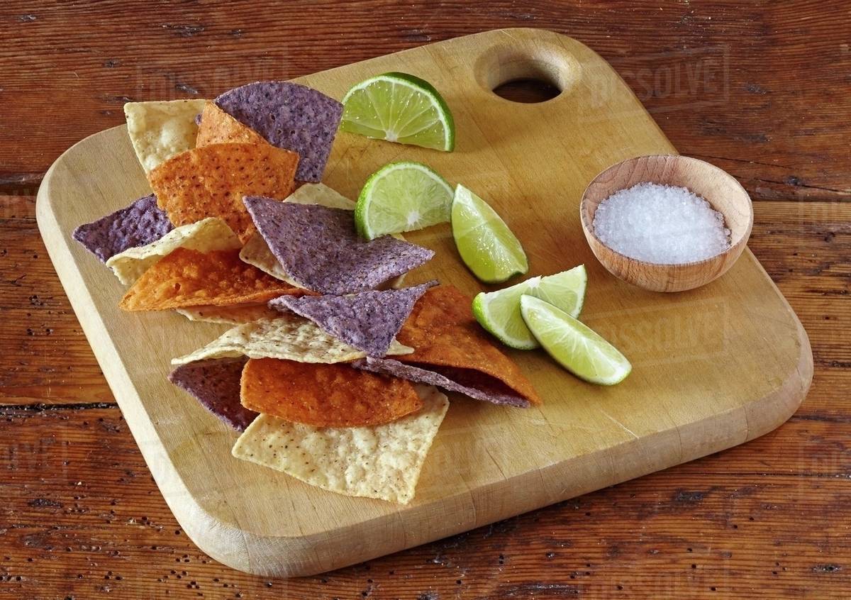 Colored tortilla chips with limes and salt - Royalty-free Stock Photo ...