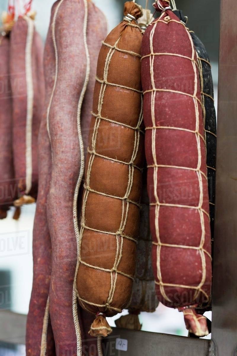 Various types of salami hanging in a butcher's - Stock Photo - Dissolve