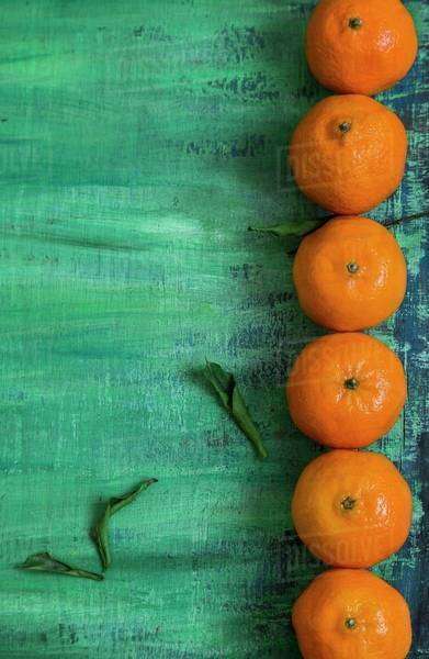 A row of clementines on a turquoise surface - Royalty-free Stock Photo ...