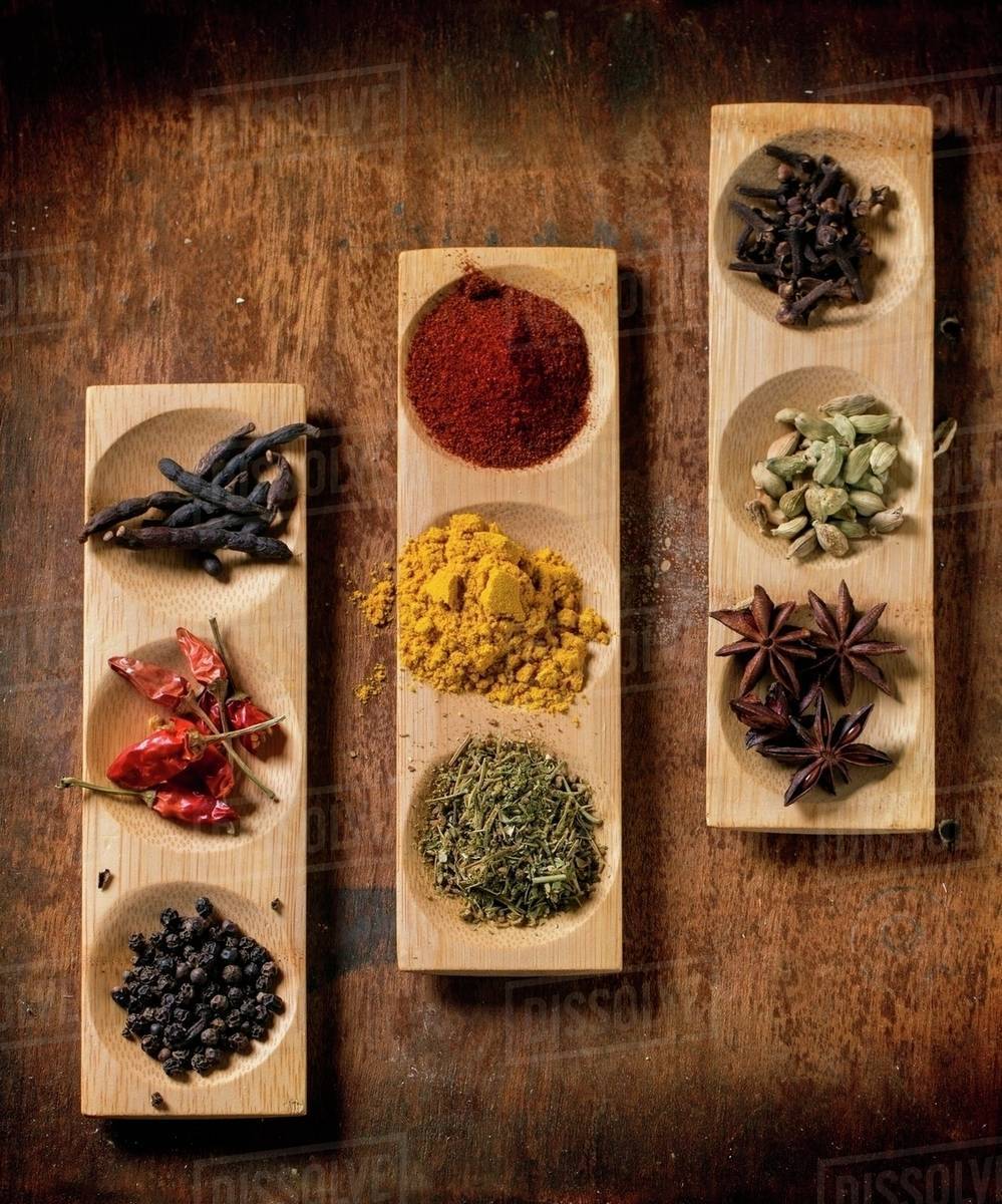 Various spices in wooden dishes (seen from above) - Stock Photo - Dissolve
