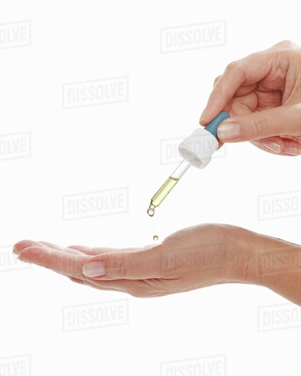 Liquid being dripped onto the palm of the hand with a pipette - Royalty ...
