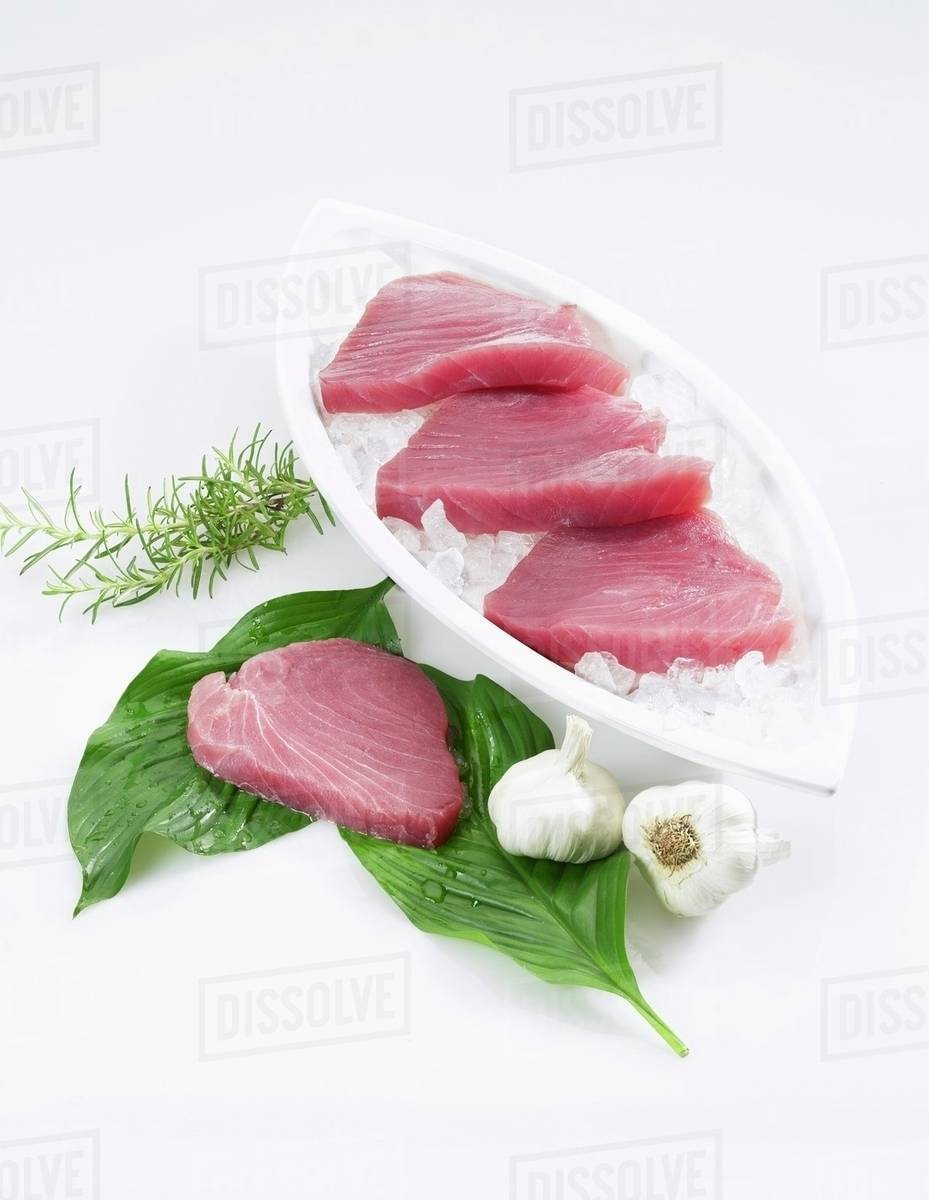 Fresh tuna fillets, garlic and rosemary - Stock Photo - Dissolve