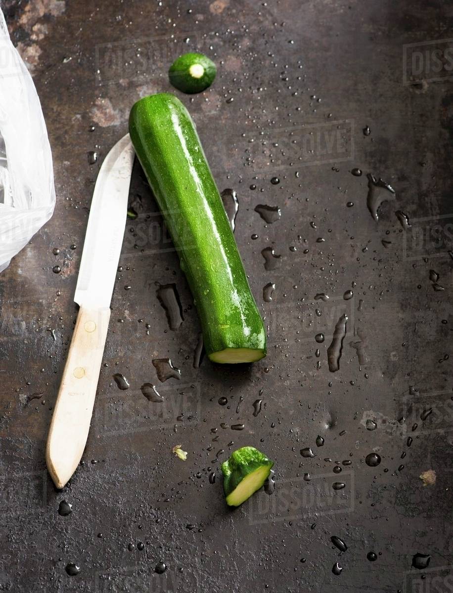 A courgette with a knife on a metal surface - Royalty-free Stock Photo ...