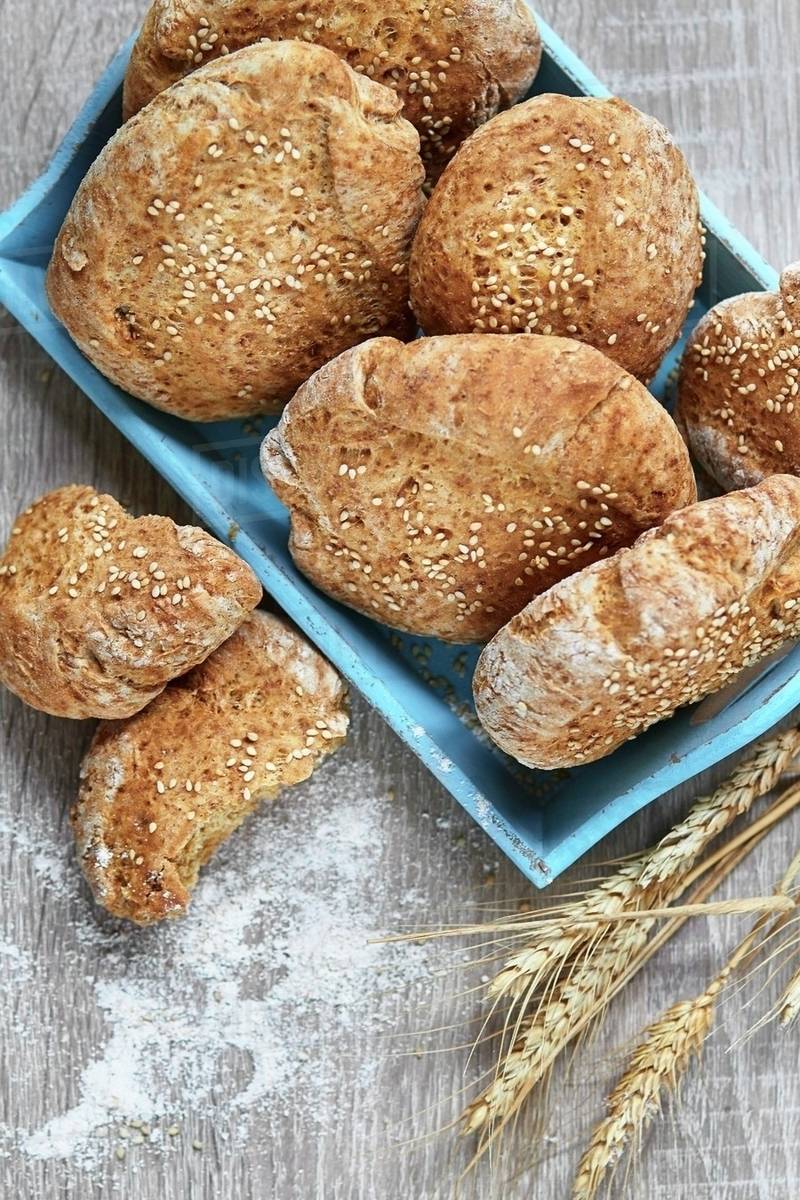 Sesame seed rolls on a wooden board - Stock Photo - Dissolve