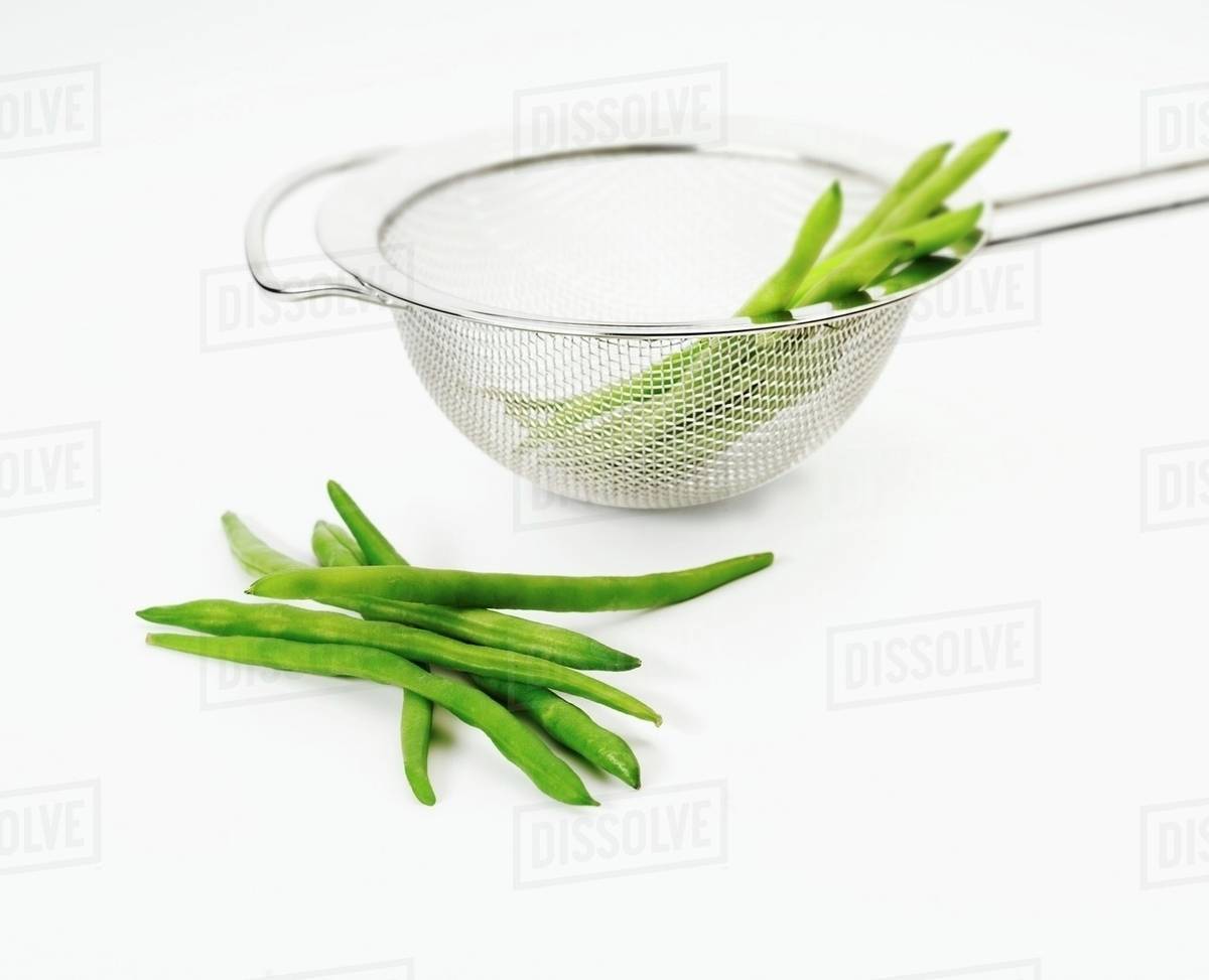 Fresh runner beans in and next to a sieve - Stock Photo - Dissolve