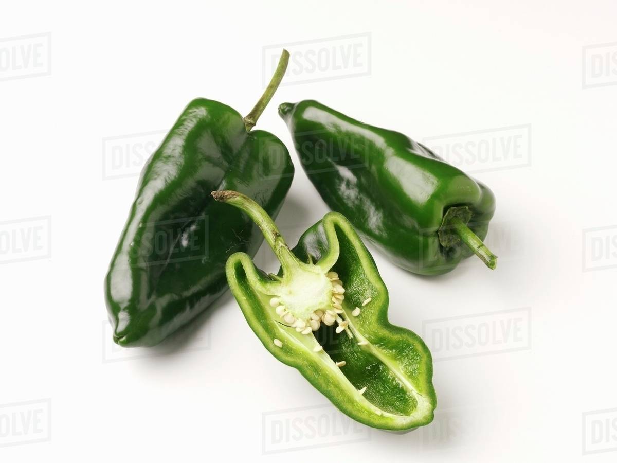 Poblano chilli peppers, whole and halved - Stock Photo - Dissolve