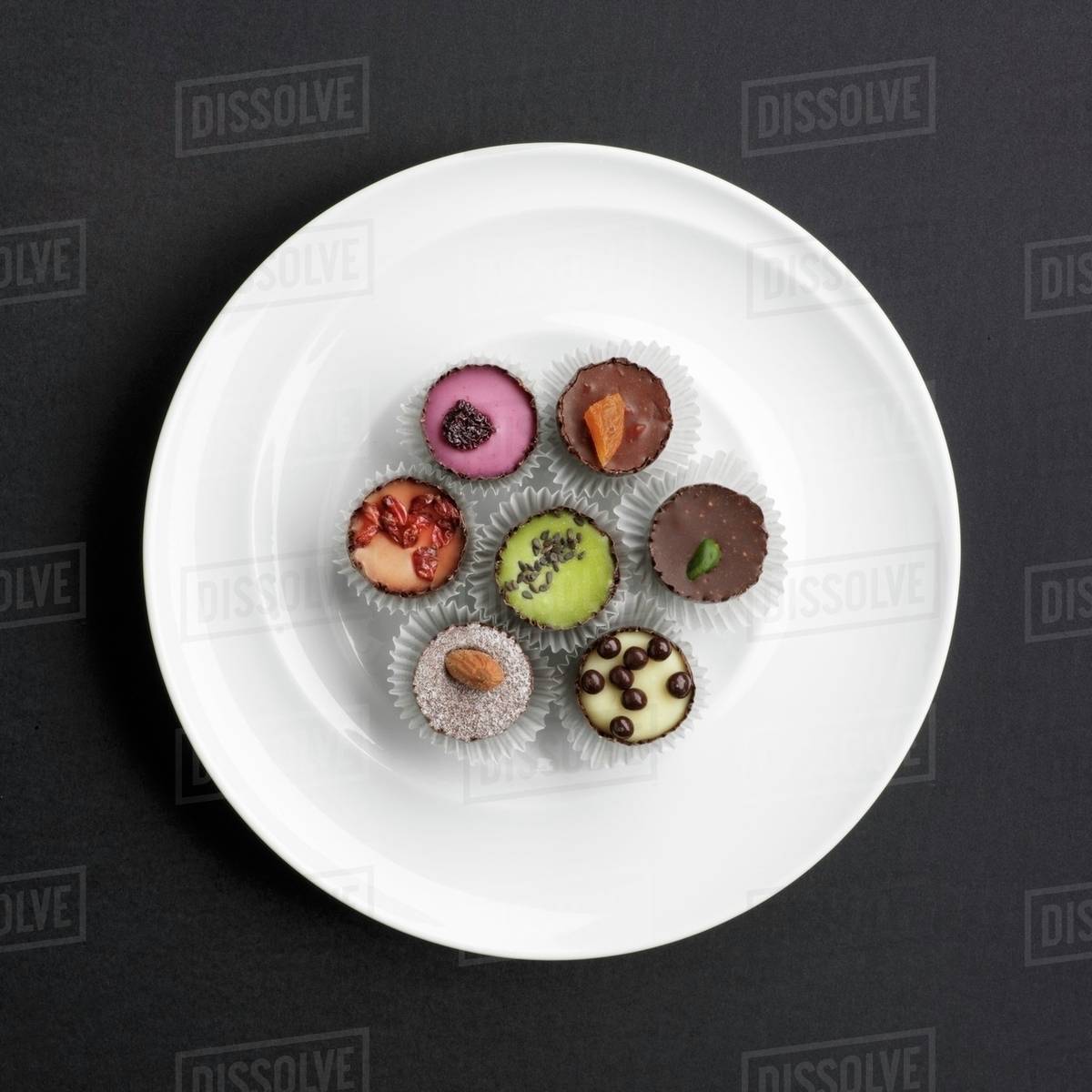 Assorted hand-made filled chocolates on a plate (view from above ...