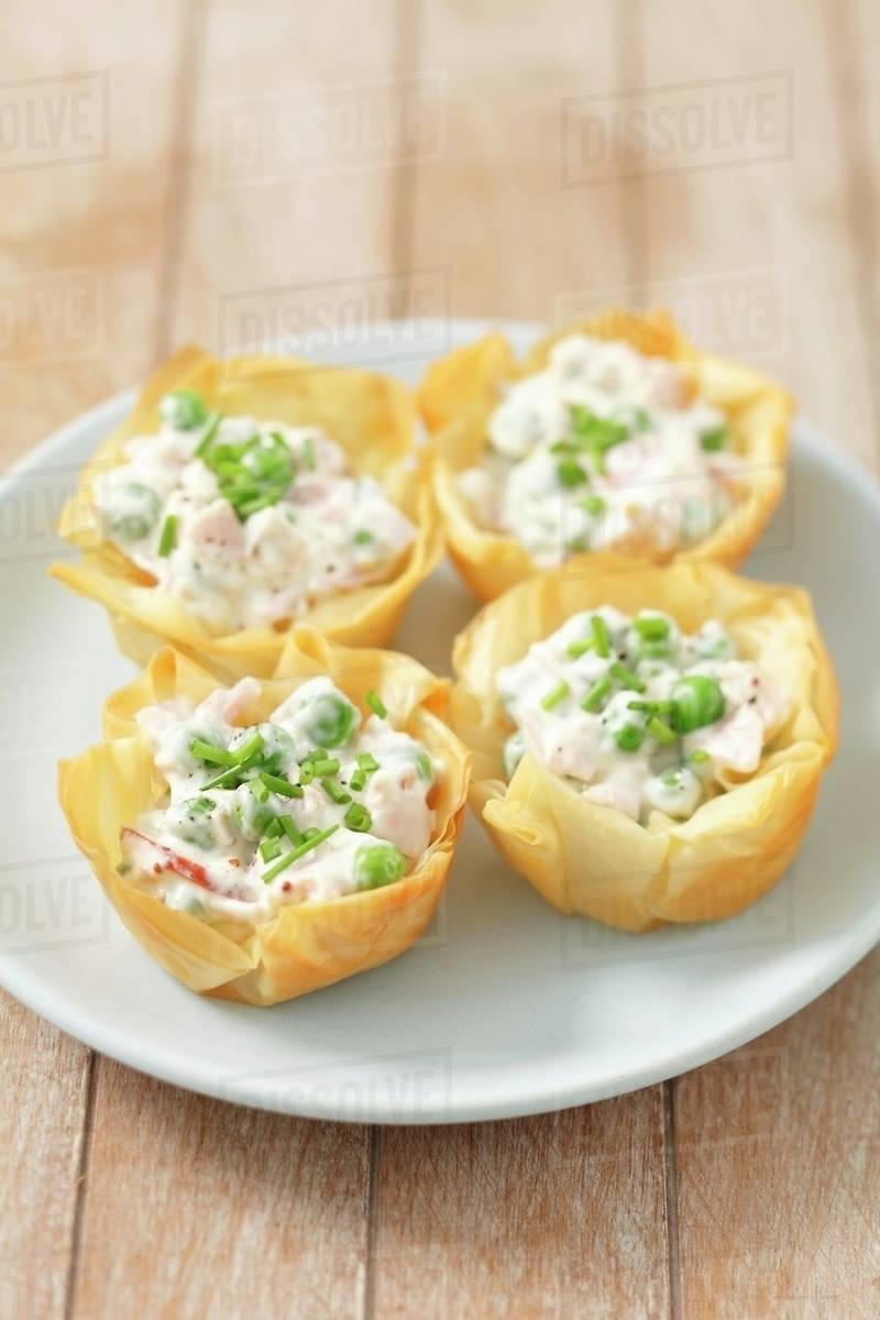 Filo pastry tartlets with ham, green peas and mayo salad - Stock Photo ...