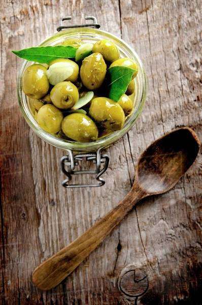 Preserved olives on a wooden surface - Royalty-free Stock Photo | Dissolve