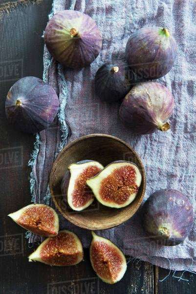 Fresh red figs, whole, halved and quartered - Stock Photo - Dissolve