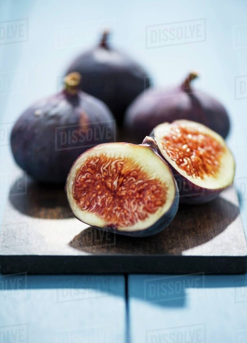 Fresh red figs on a chopping board, one cut in half - Royalty-free ...