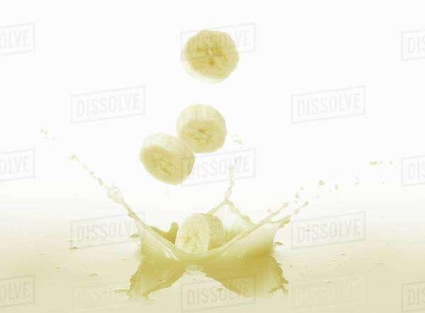 Slices of banana dropping into banana juice - Stock Photo - Dissolve