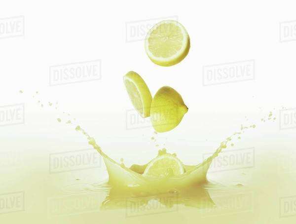Lemons falling into lemon juice - Stock Photo - Dissolve