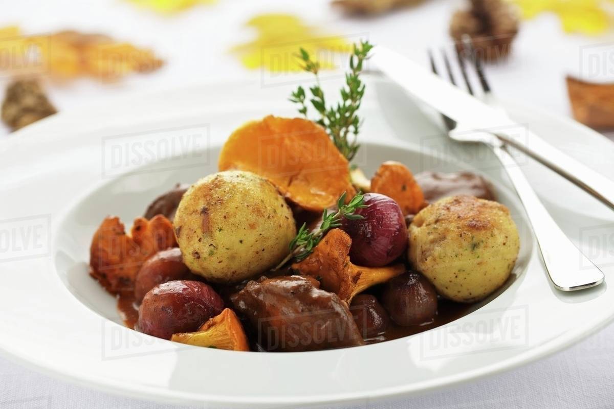 Venison ragout with baked semolina dumplings and chanterelles - Stock ...