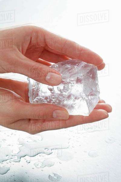 Hands holding a piece of ice - Royalty-free Stock Photo | Dissolve