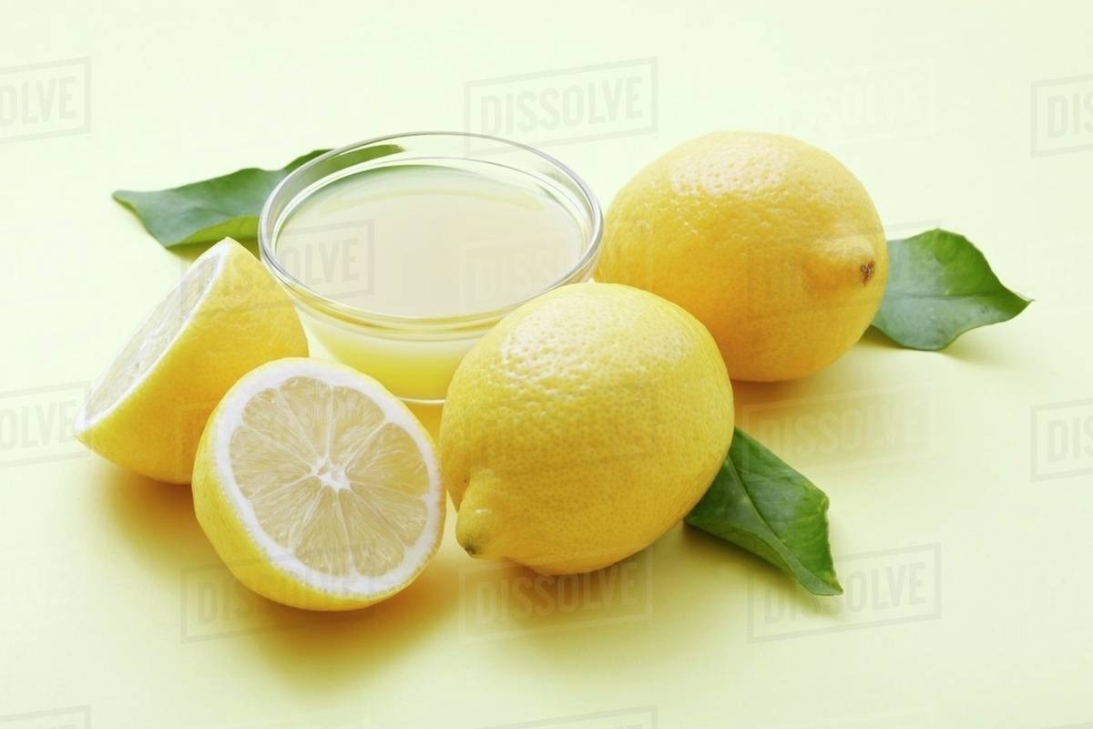 A bowl of lemon juice and fresh lemons - Royalty-free Stock Photo ...