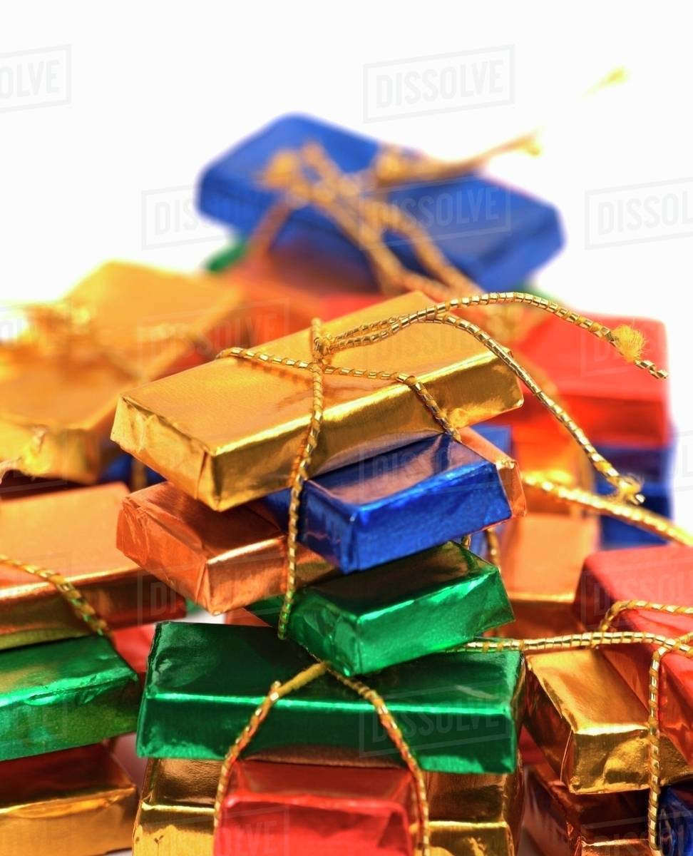 Mini chocolate bars tied with gold string - Stock Photo - Dissolve