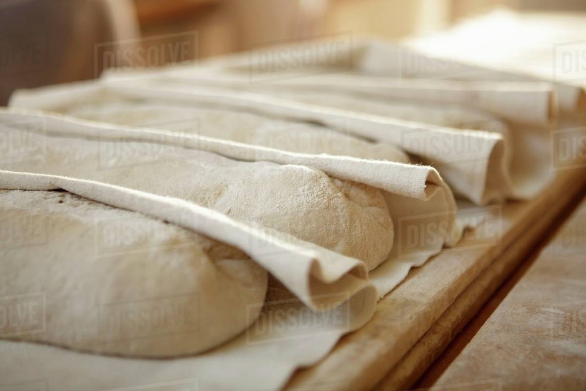 Unbaked bread on folded linen cloth - Stock Photo - Dissolve