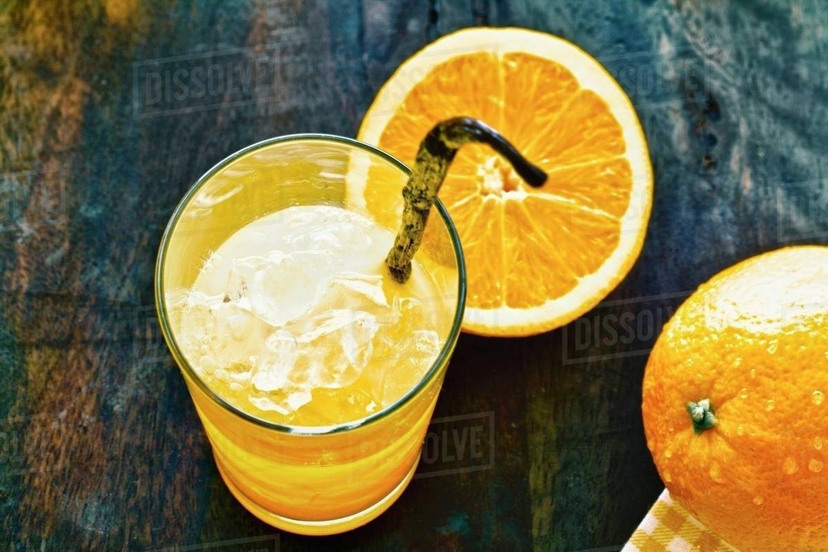 Orange juice with a vanilla pod and ice cubes - Stock Photo - Dissolve