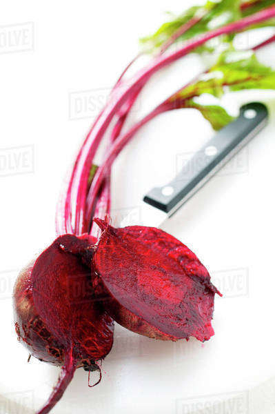 Beetroot with leaves, halved; knife - Royalty-free Stock Photo | Dissolve