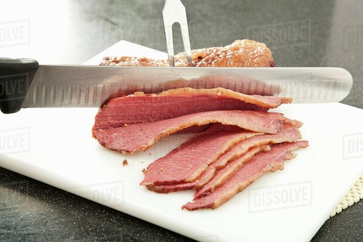 Slicing Corned Beef on a White Plastic Cutting Board - Royalty-free ...