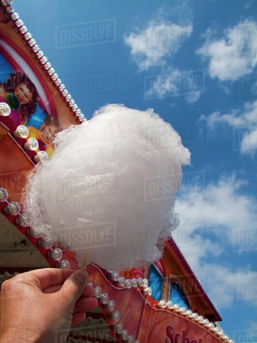 A hand holding candy floss at a fair - Royalty-free Stock Photo | Dissolve