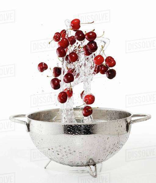 Cherries and a splash of water falling into a colander - Royalty-free ...