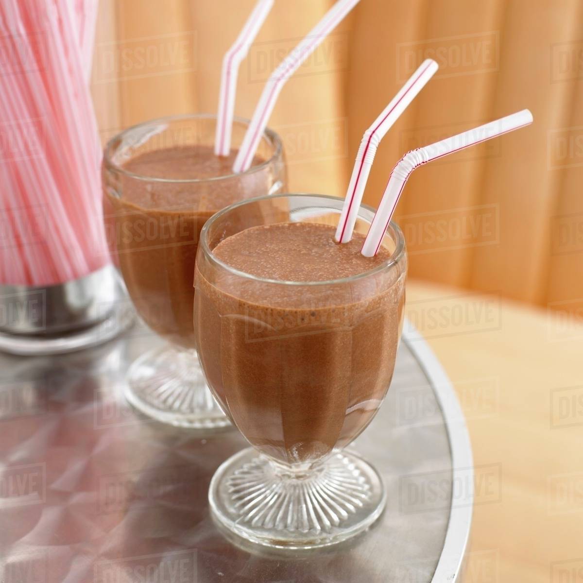 Two chocolate milkshakes with straws - Royalty-free Stock Photo | Dissolve