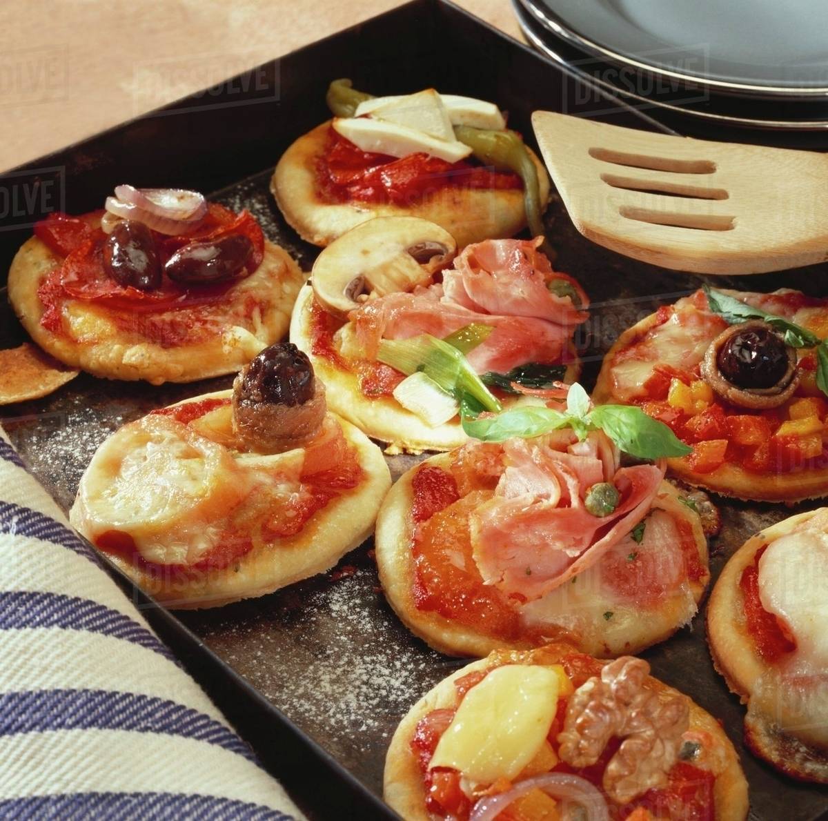 Mini-pizzas on a baking tray - Royalty-free Stock Photo | Dissolve