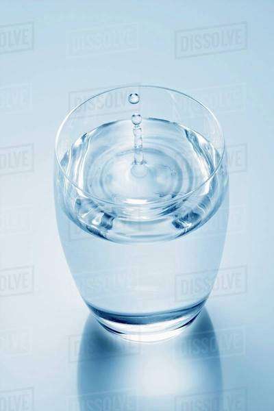 Drop of water falling into a glass - Royalty-free Stock Photo | Dissolve