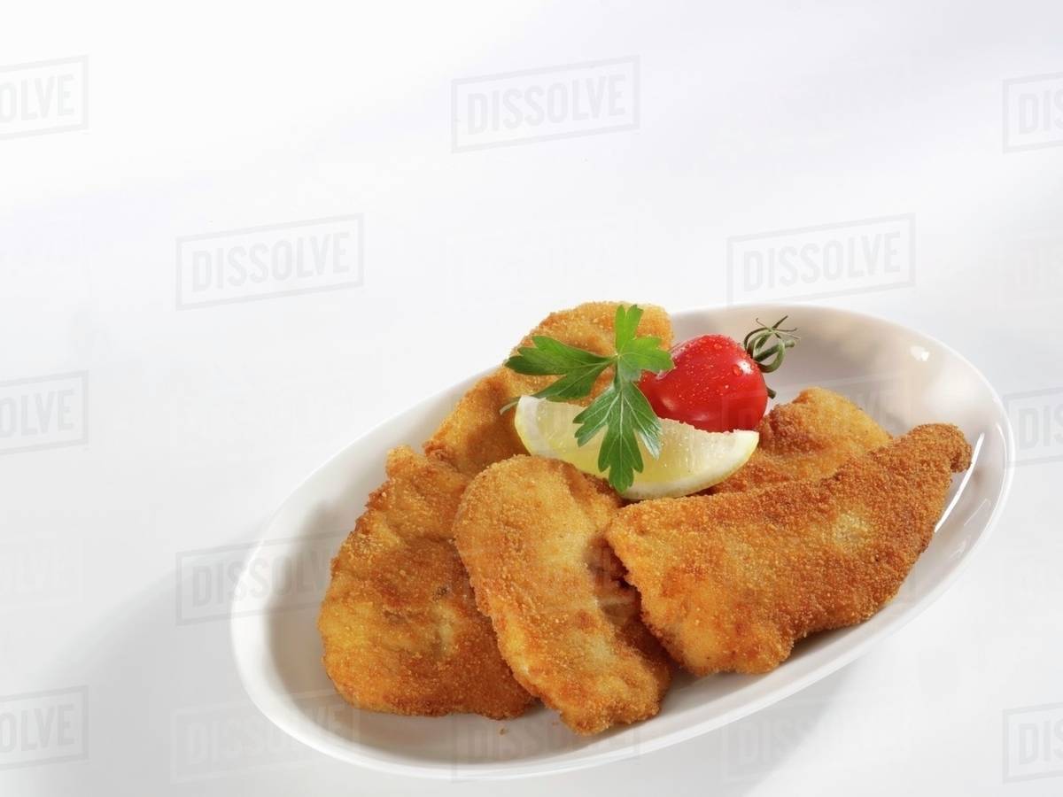 Three Wiener Schnitzels (veal escalopes) on a serving plate - Stock ...