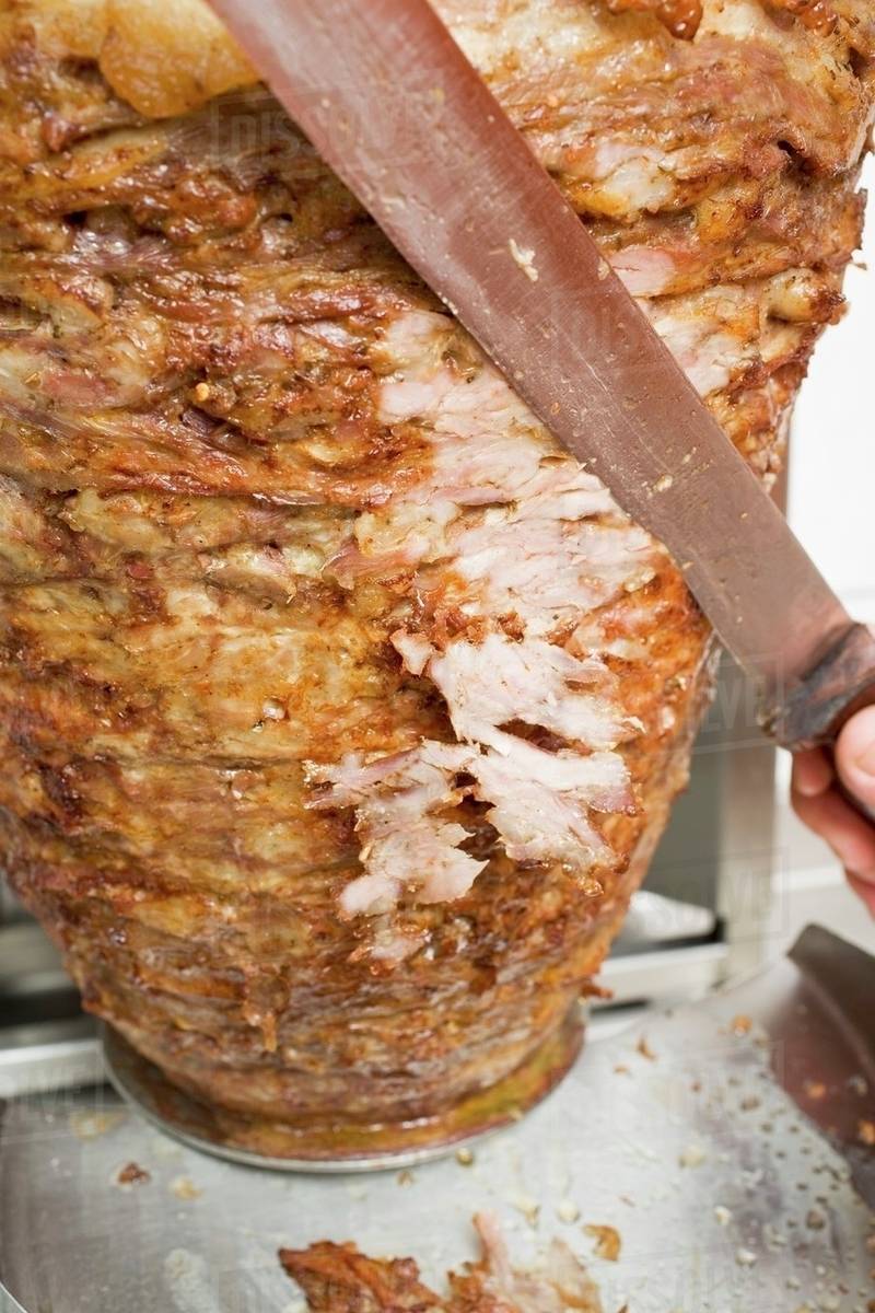 Slicing doner meat from the spit - Royalty-free Stock Photo | Dissolve
