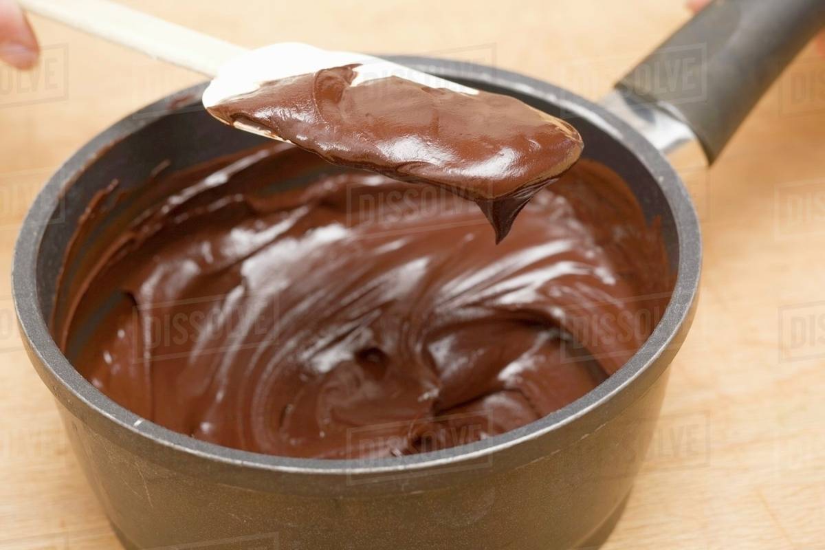 Melted chocolate on spatula and in pan - Royalty-free Stock Photo ...