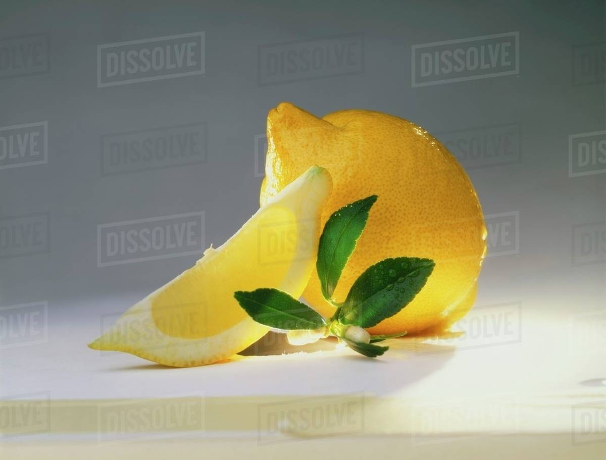 Whole lemon and lemon wedge, lemon leaves - Royalty-free Stock Photo ...