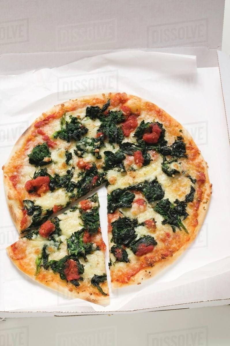 Spinach, tomato and cheese pizza in pizza box - Stock Photo - Dissolve