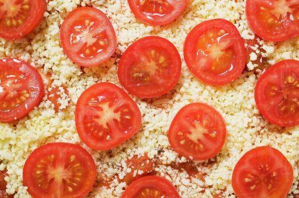 Cheese and tomato pizza (unbaked), full-frame - Stock Photo - Dissolve