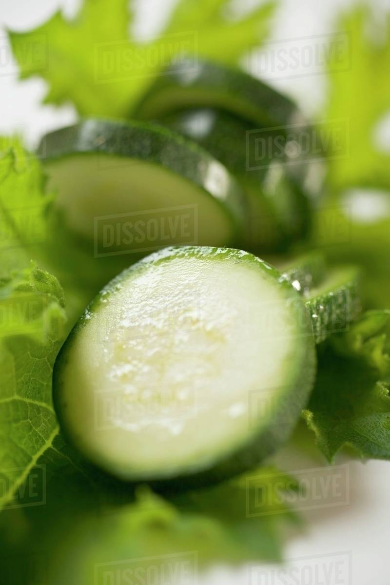 Courgette slices on courgette leaf - Stock Photo - Dissolve