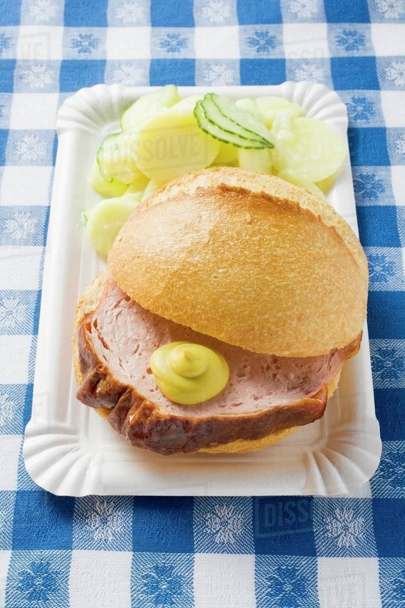 Leberkase in roll with mustard & potato salad on paper plate - Royalty ...