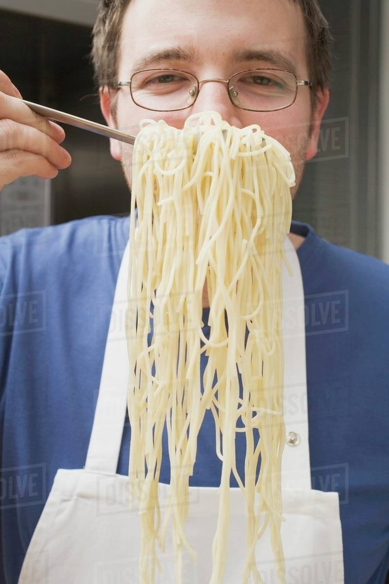 Chef holding up cooked spaghetti on spaghetti server - Royalty-free ...
