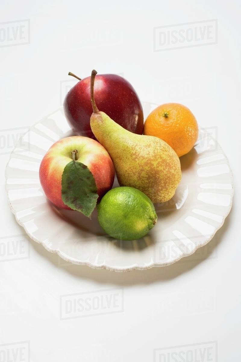 Core fruit and citrus fruit on white plate - Stock Photo - Dissolve