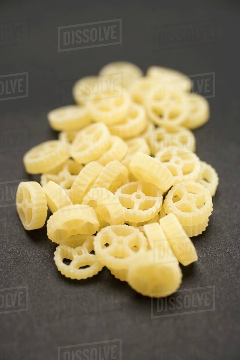 Wagon wheel pasta on black background - Royalty-free Stock Photo | Dissolve