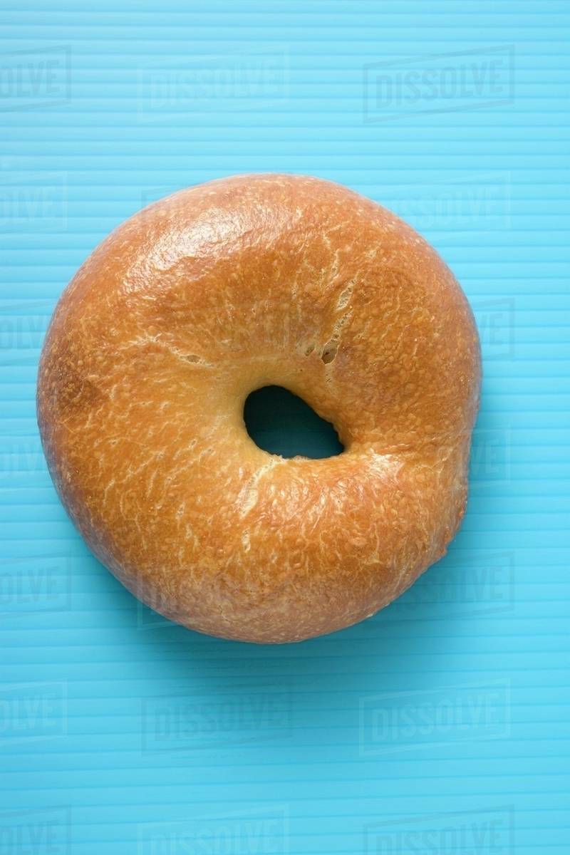 Bagel on blue background - Stock Photo - Dissolve