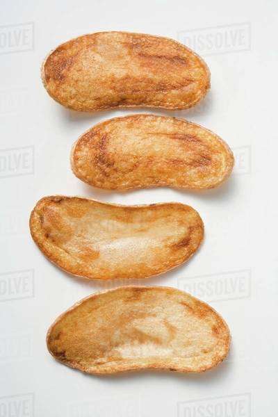 Four home-made potato crisps - Royalty-free Stock Photo | Dissolve