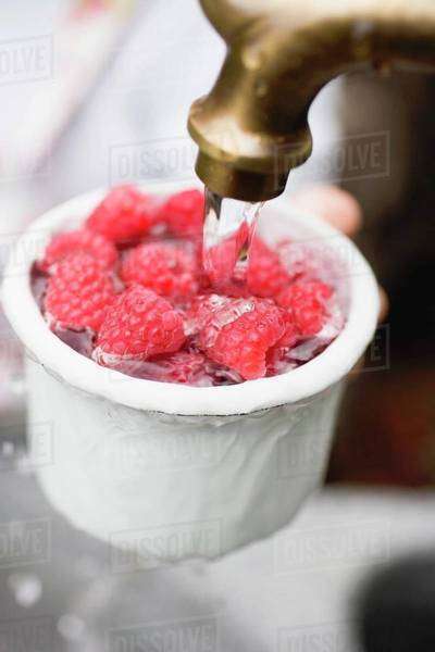 Washing raspberries - Royalty-free Stock Photo | Dissolve
