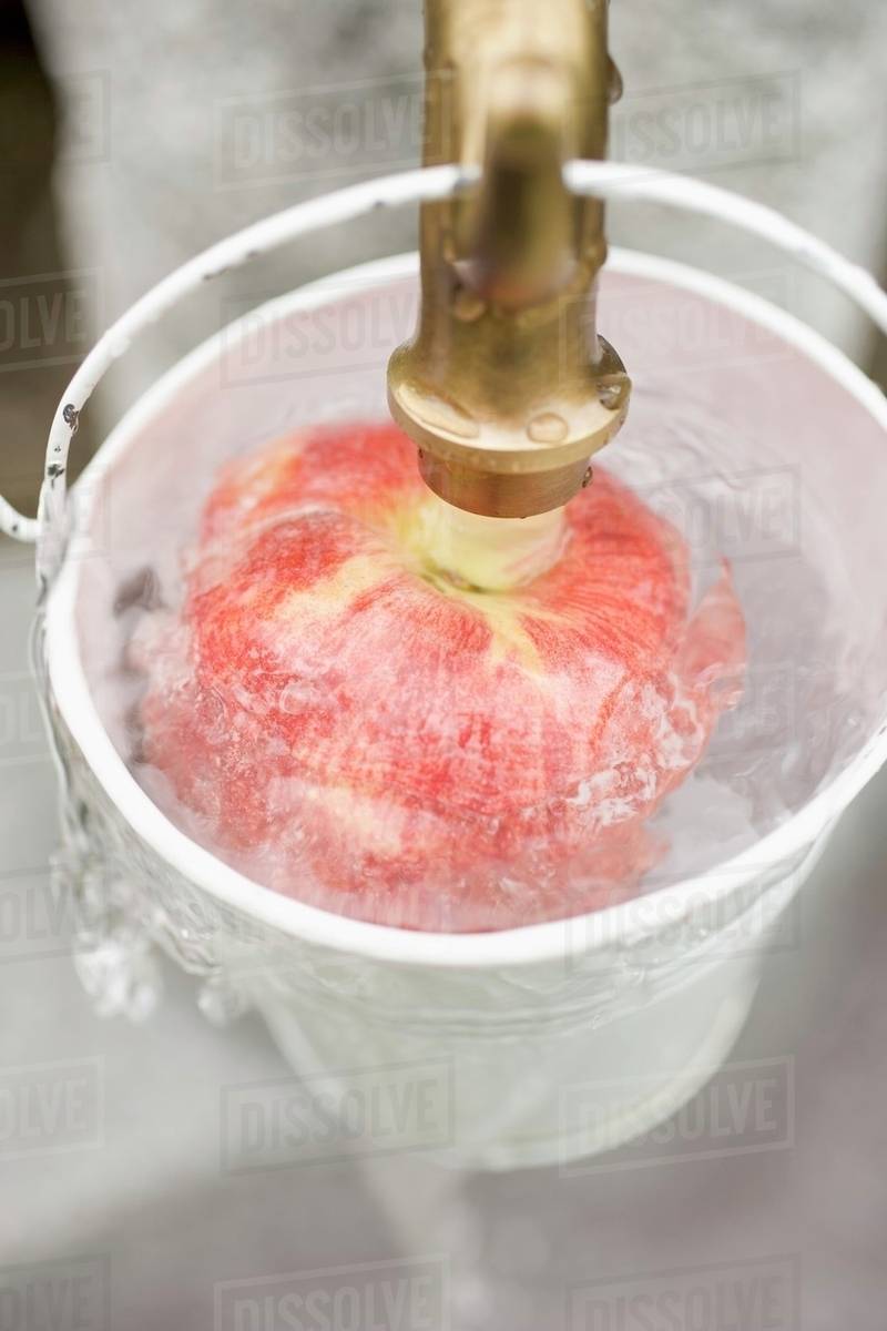 Washing an apple in a bucket under tap - Royalty-free Stock Photo ...